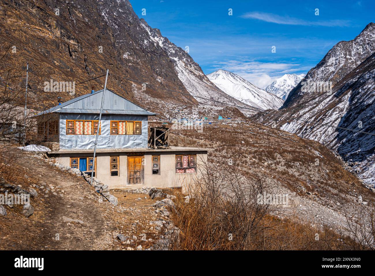 Tserko Ri and Gangchempo towers over a rustic house in the Himalayas ...