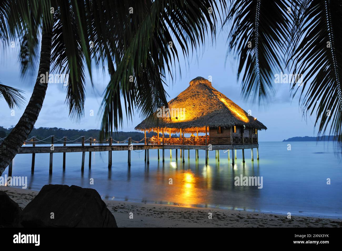 Bar and restaurant on stilts at dusk, Playa Tortuga hotel, Colon Island ...