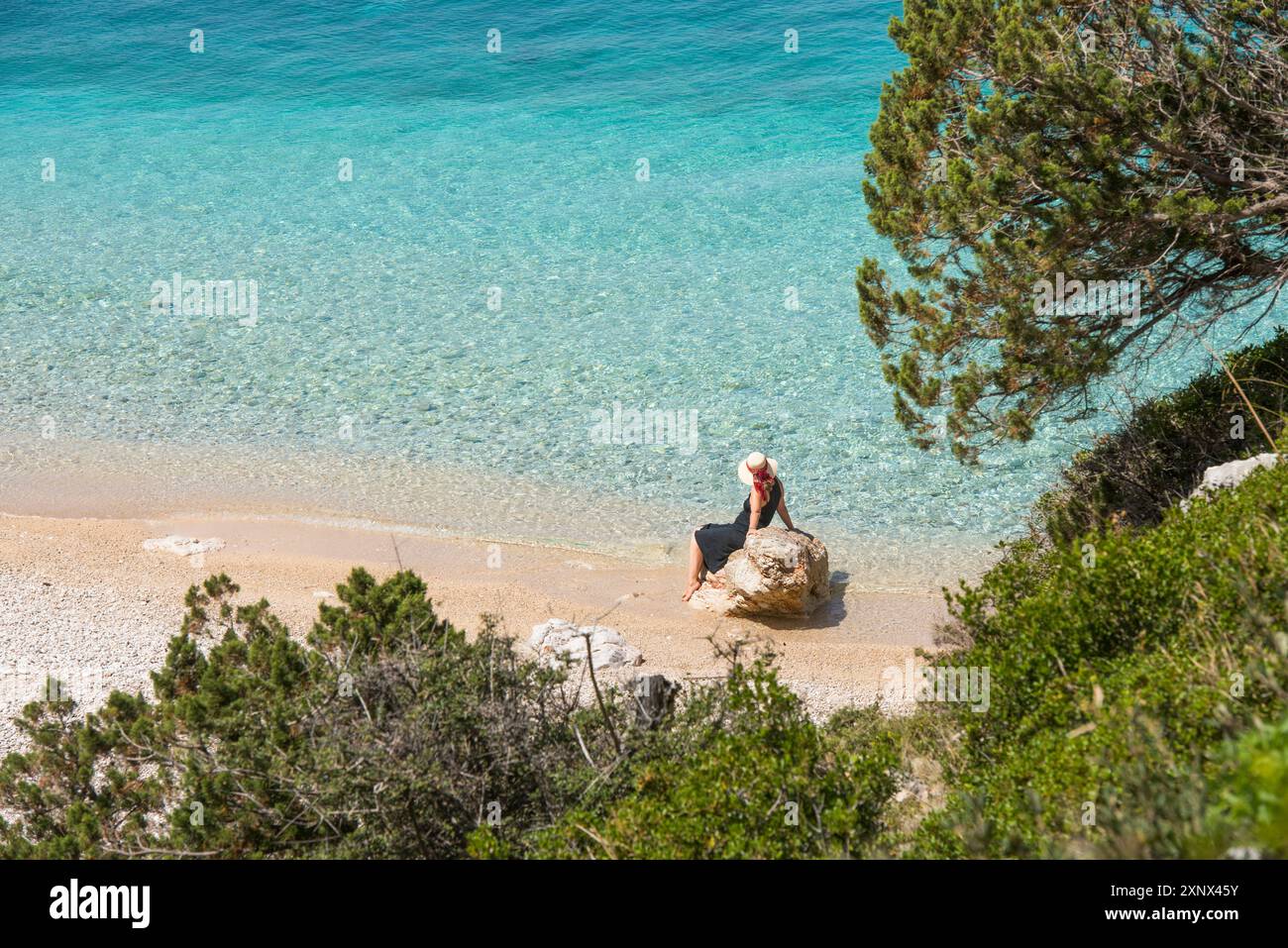 Woman sitting on a rock at the Beach of Dafines Bay, Peninsula of ...
