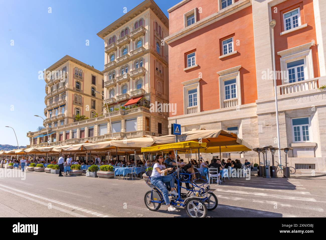 View of pastel coloured architecture, restaurants and cafes on seafront ...
