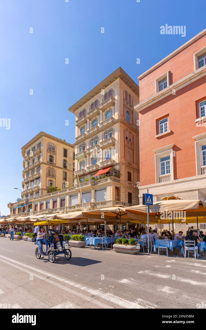 View of pastel coloured architecture, restaurants and cafes on seafront ...
