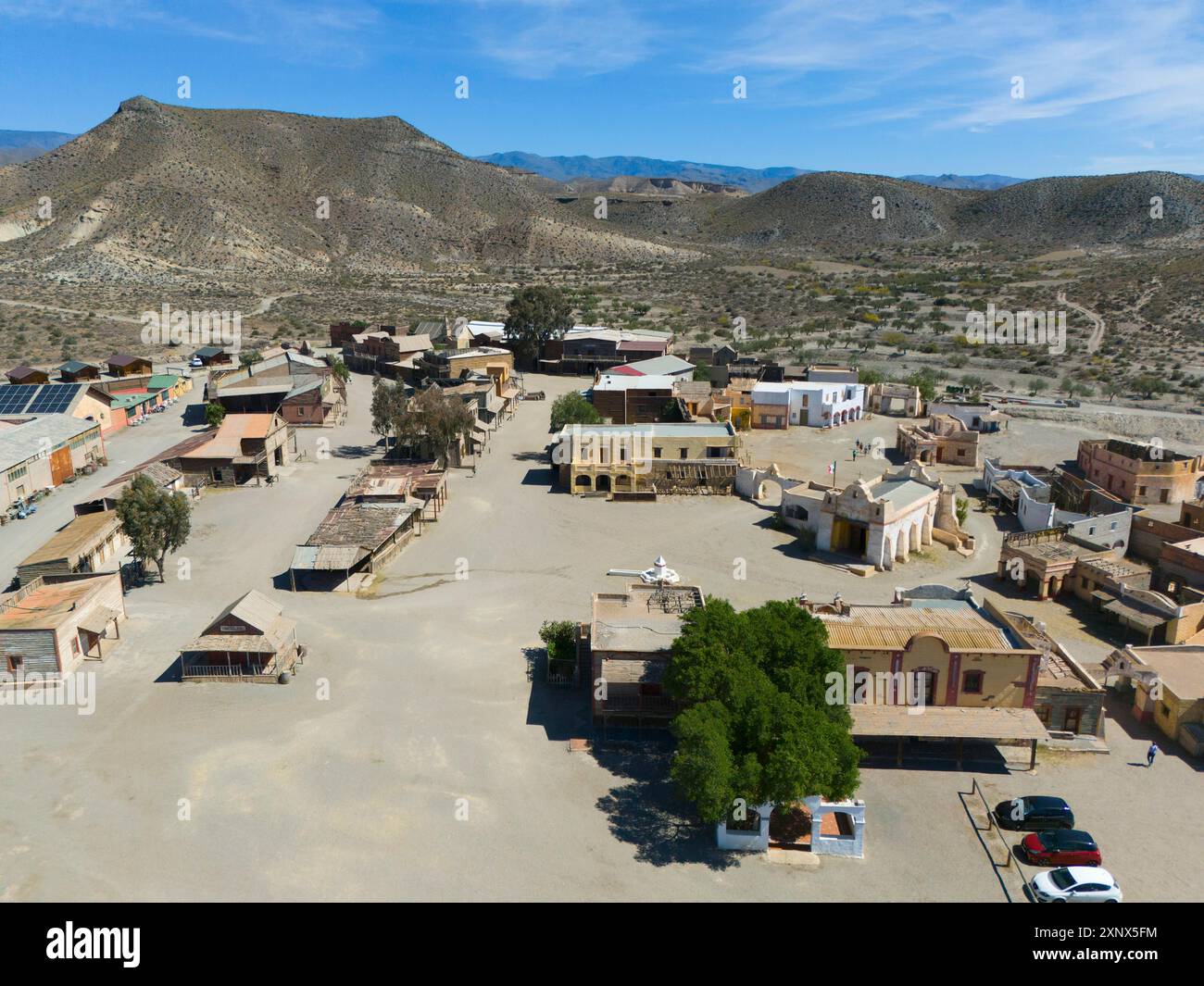 A western town with scattered trees and historic buildings in a dry ...