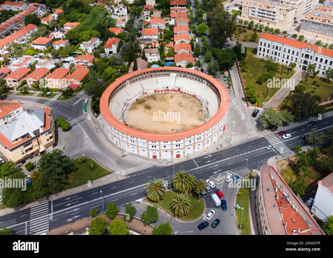 Aerial view of a historic bullring with red roofs, embedded in a town ...