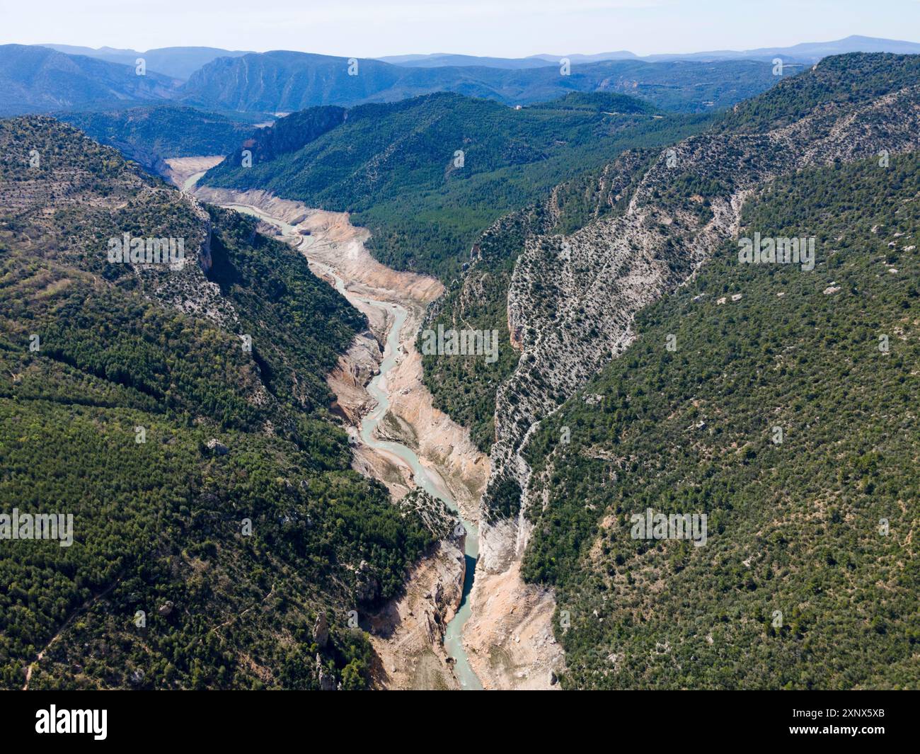A narrow river flowing through a narrow gorge with high, wooded rock ...