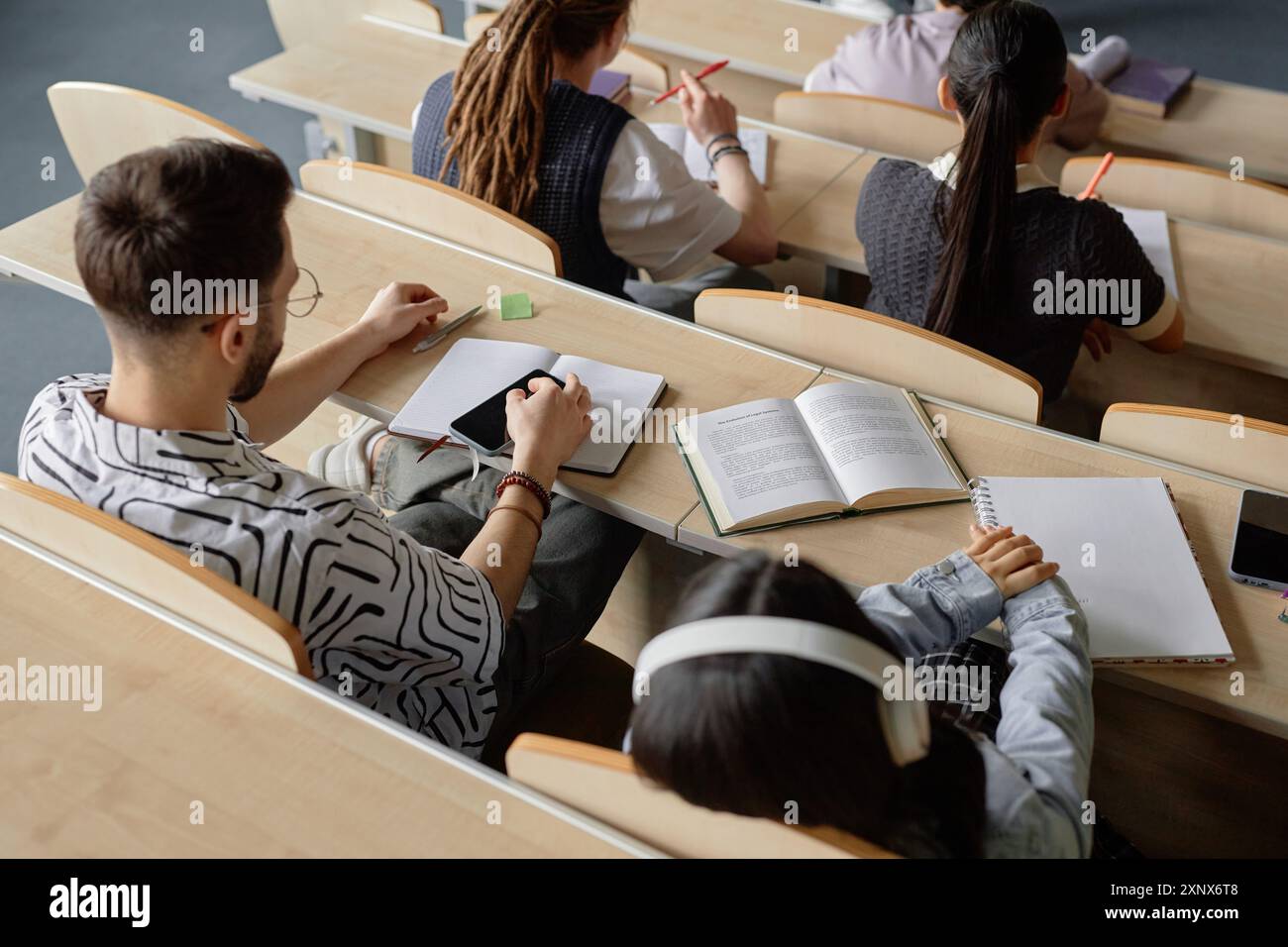 High angle shot of disinterested students sitting at desk with ...