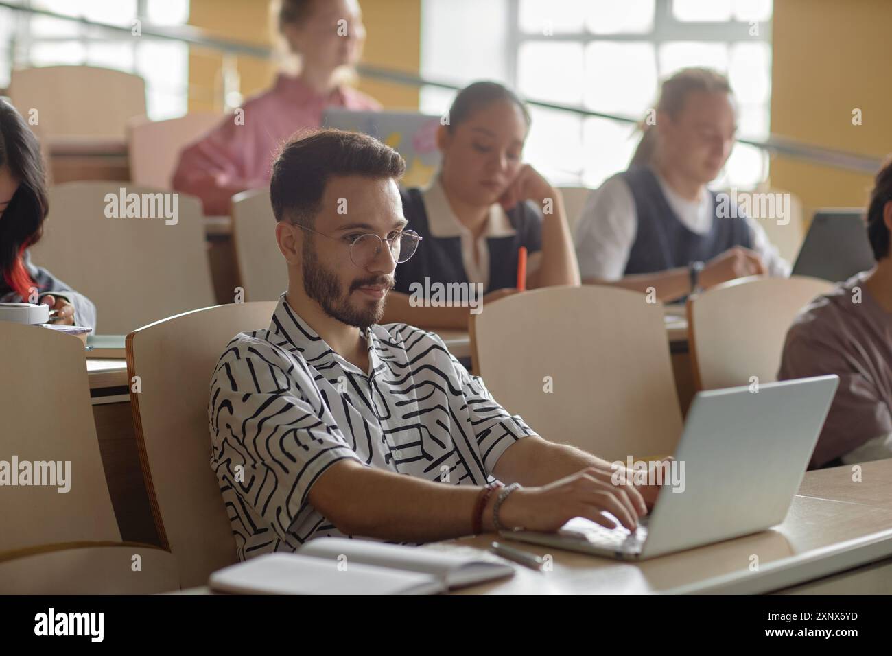 Yong Middle Eastern male student with neat beard studying using laptop ...