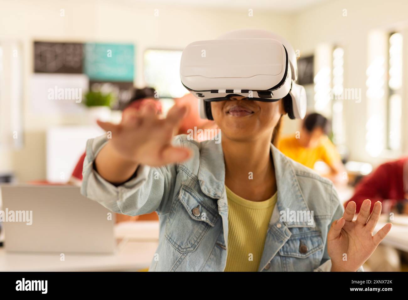 Using VR headset, teenager exploring virtual reality in high school classroom Stock Photo - Alamy
