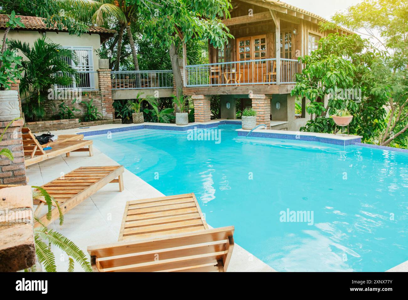 A crystal clear swimming pool surrounded by trees. Concept of home ...