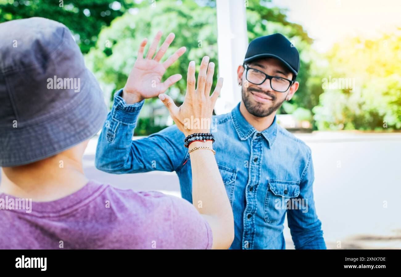 Two smiling friends shaking hands on the street. Friends shaking hands ...