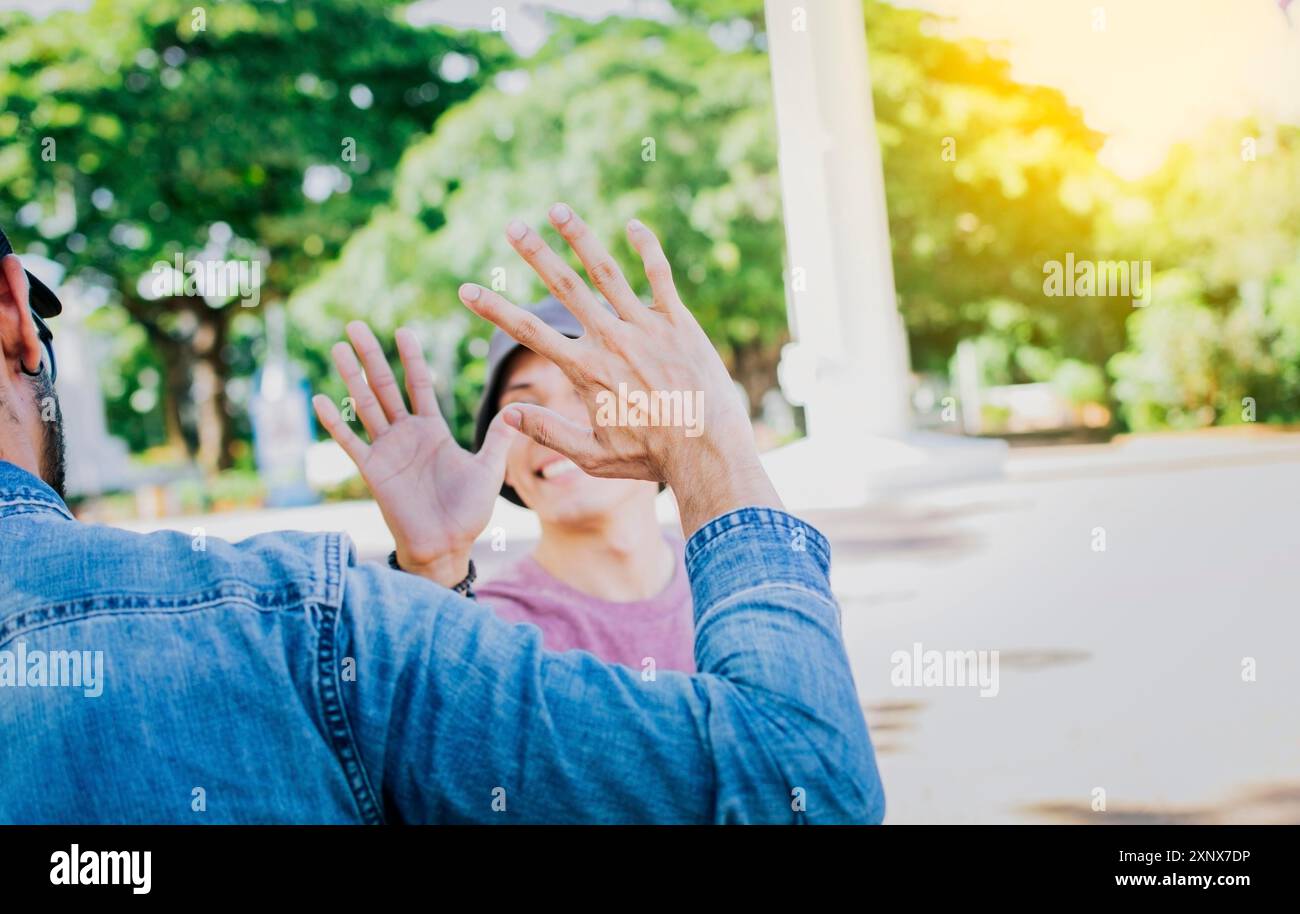 Close up of smiling people shaking hands outdoors. Back view of two ...