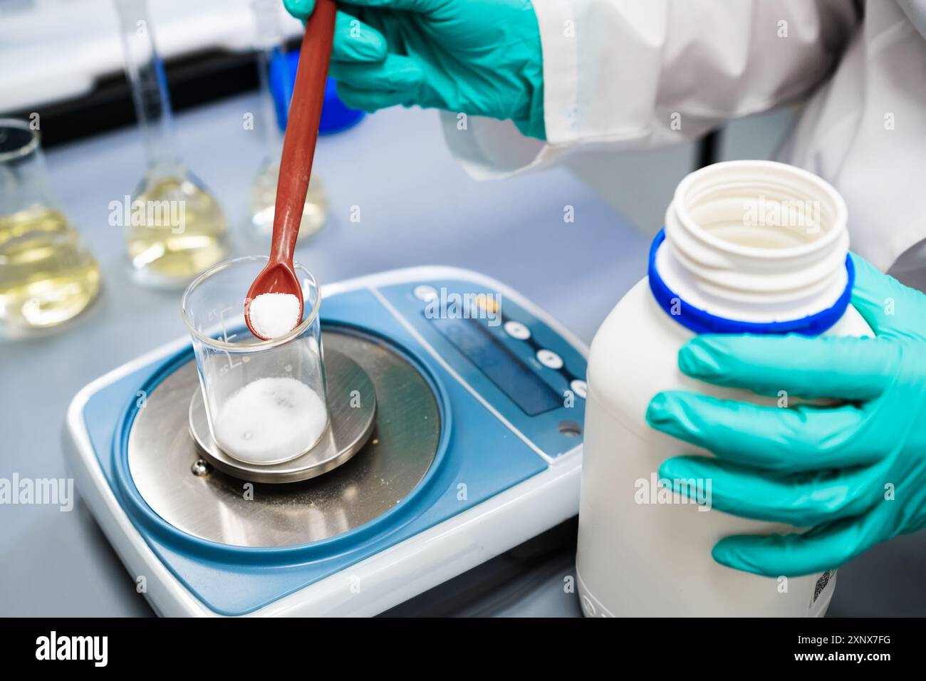 Powder samples being weighed by a woman using laboratory balances Stock ...