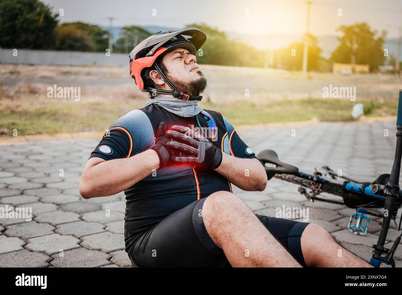 Cyclist on the pavement with chest pain. Concept of cyclist suffering ...