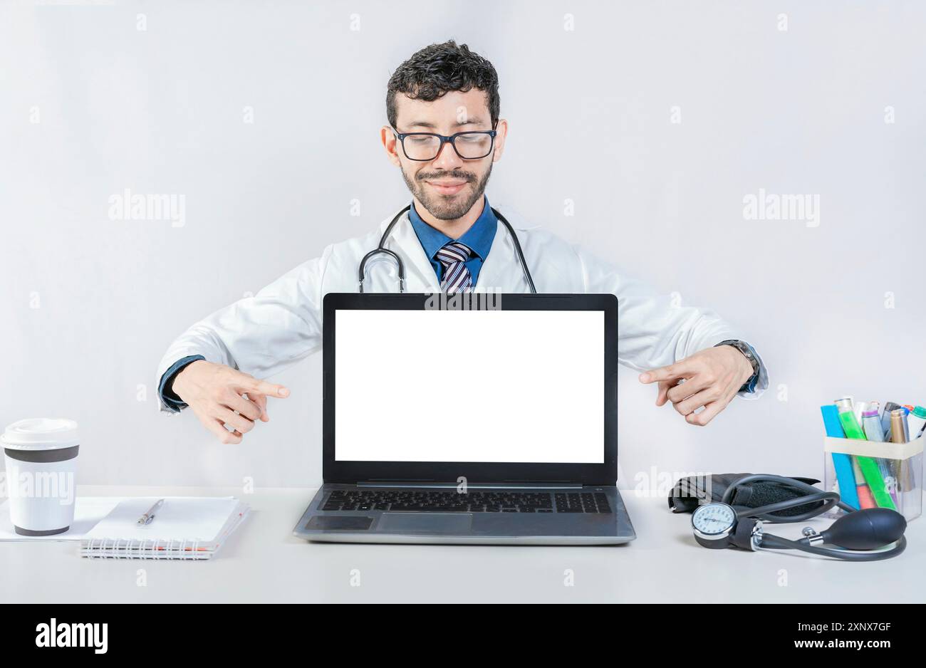 Handsome doctor pointing at an advertisement on the laptop screen ...