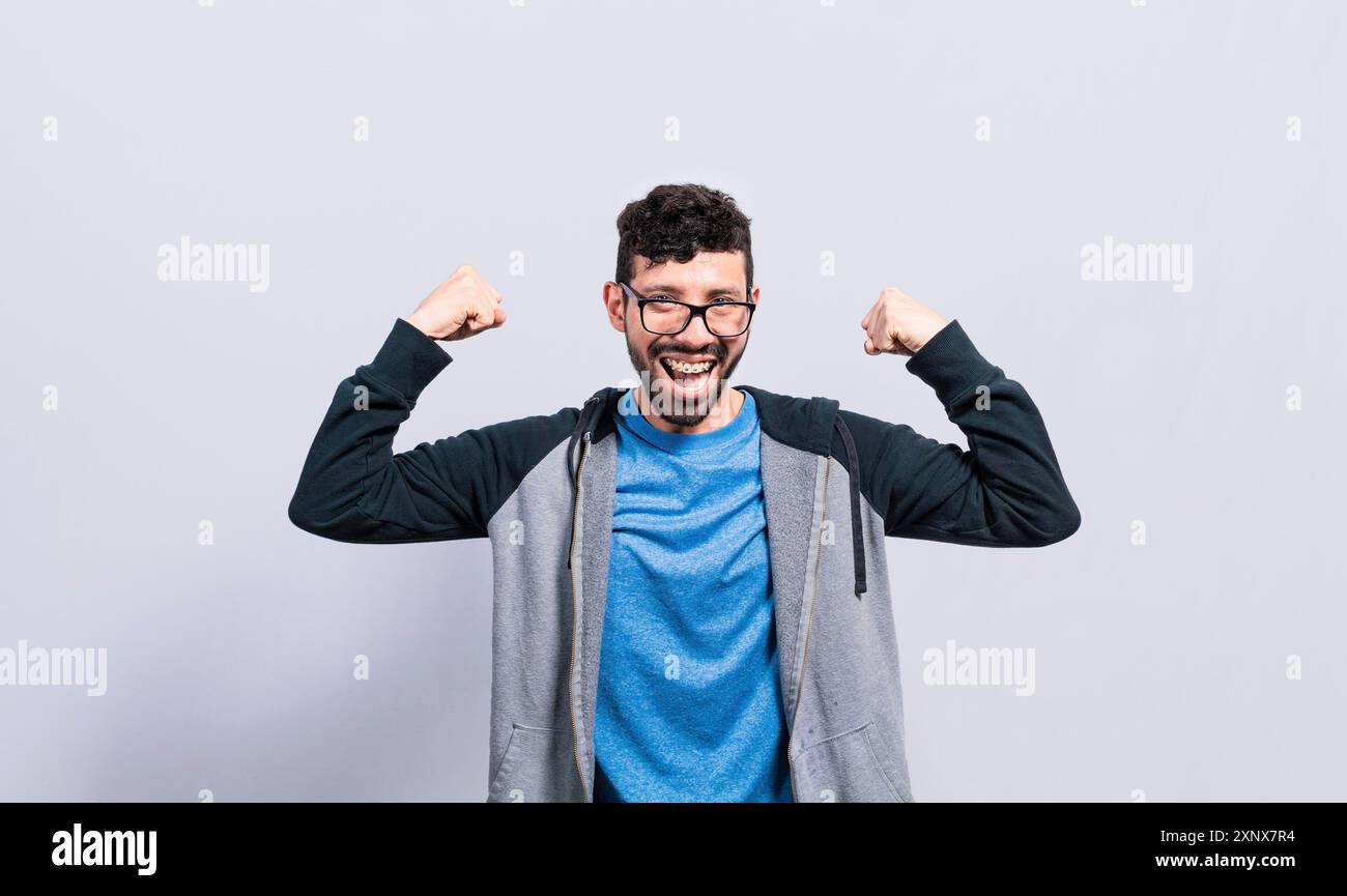 Young man with happy face raising arms in victory gesture isolated ...