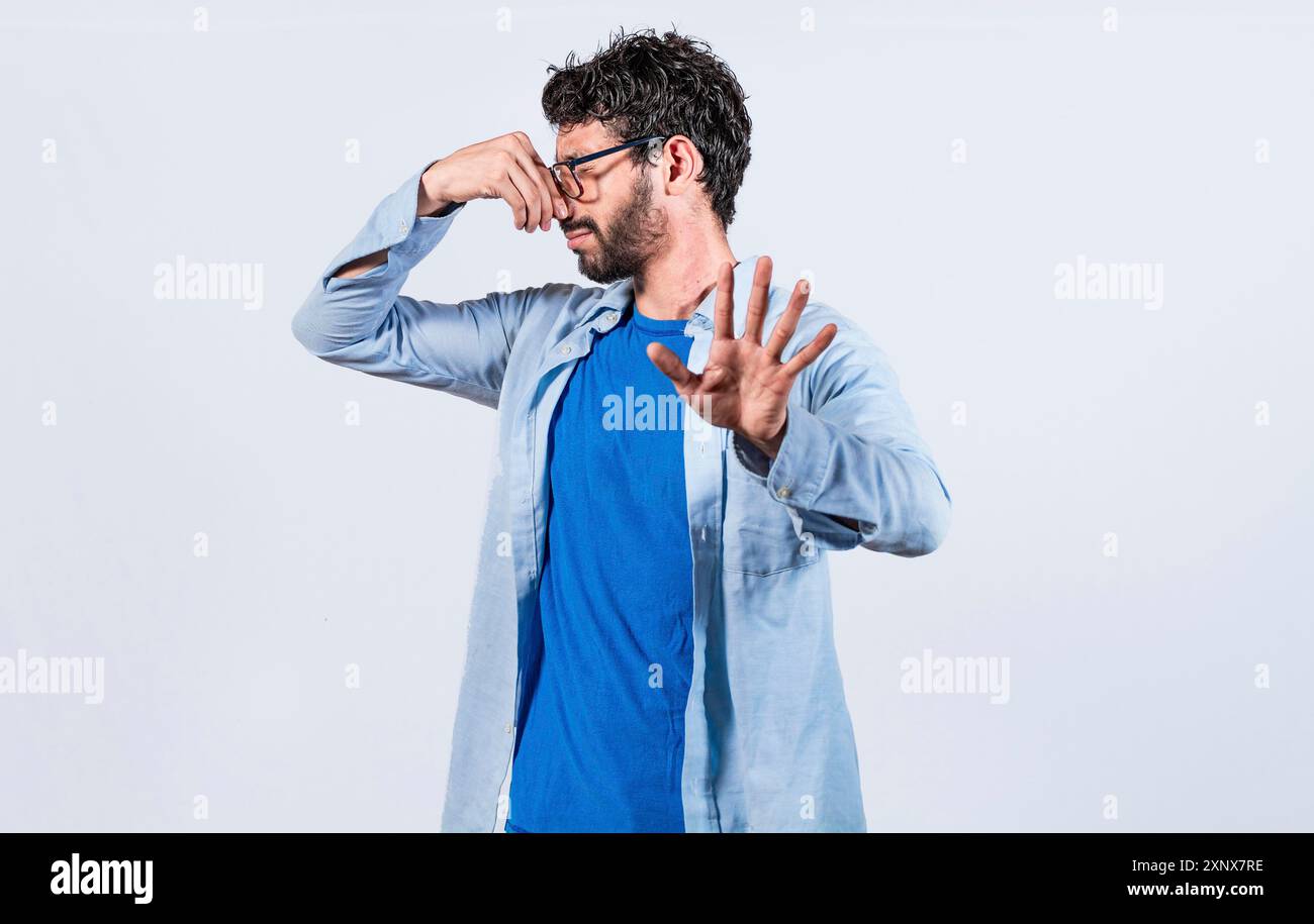 Confused unhappy man grabbing nose with fingers and stretching hand out ...