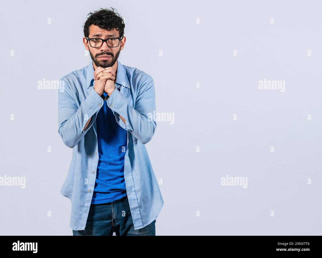 Worried man asking please isolated. Young man putting hands together ...