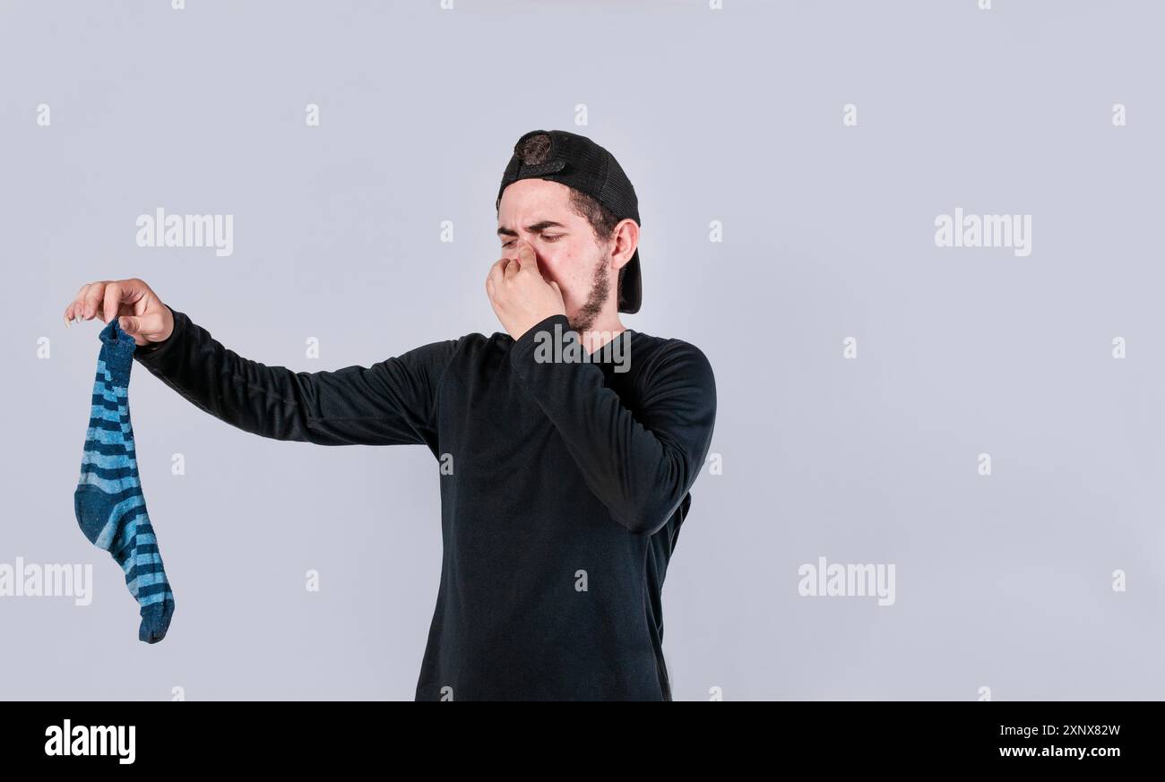 Teeneger holding a stinky sock isolated. smelly socks concept. Man ...