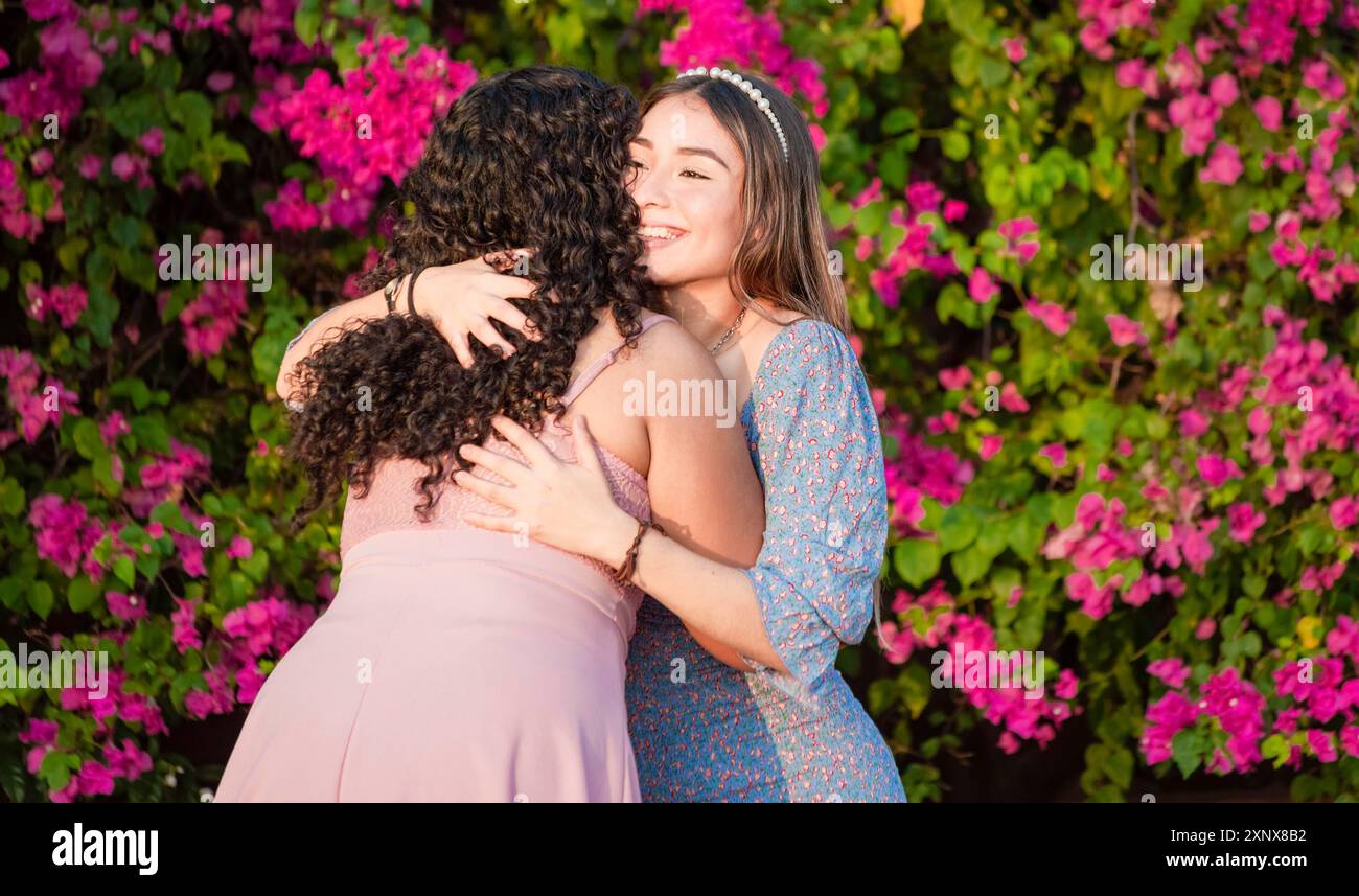 Two women friends hugging outdoors. Girl congratulating and hugging her ...