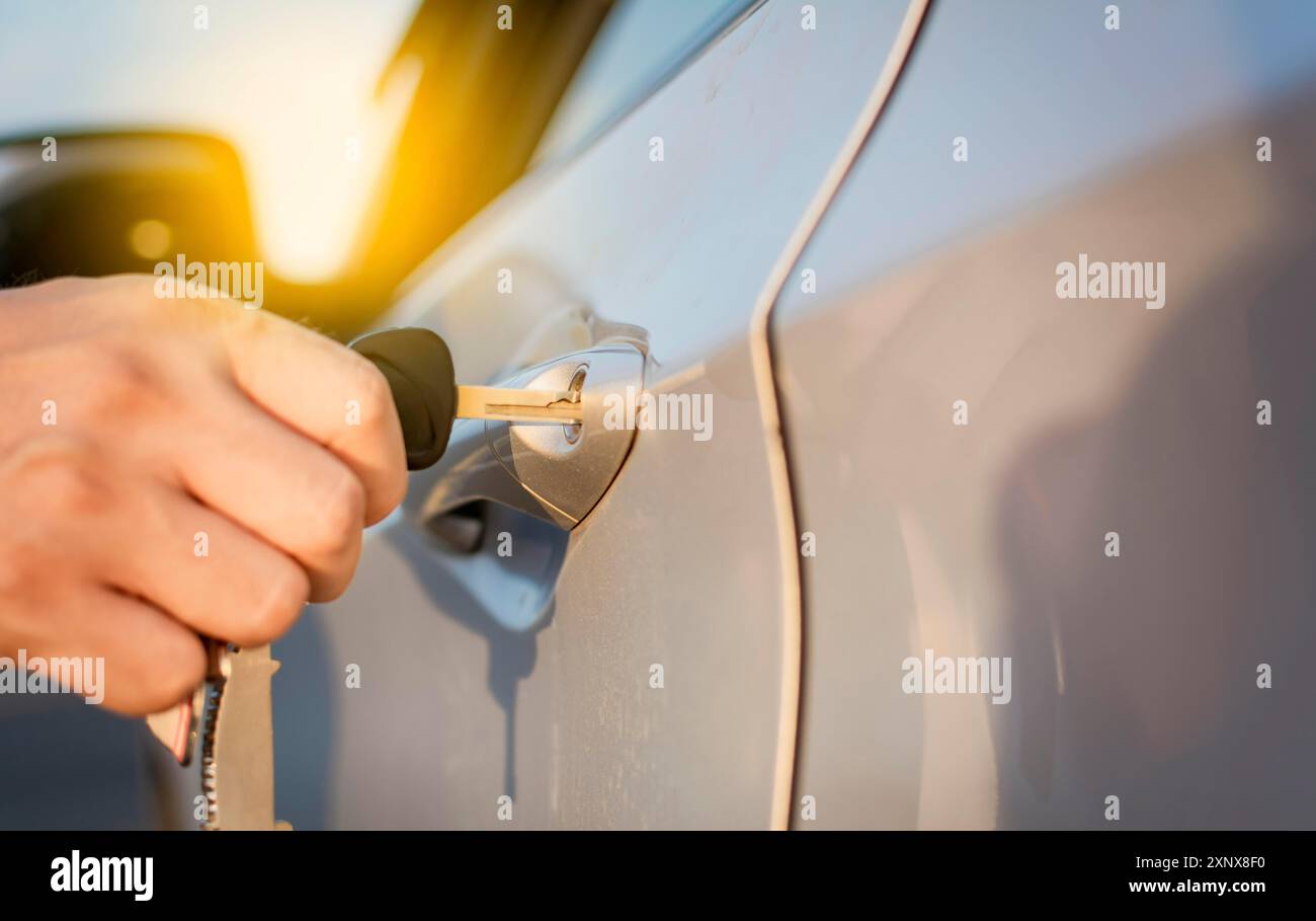 Hands with keys opening the car door. Close-up of hands opening the car ...