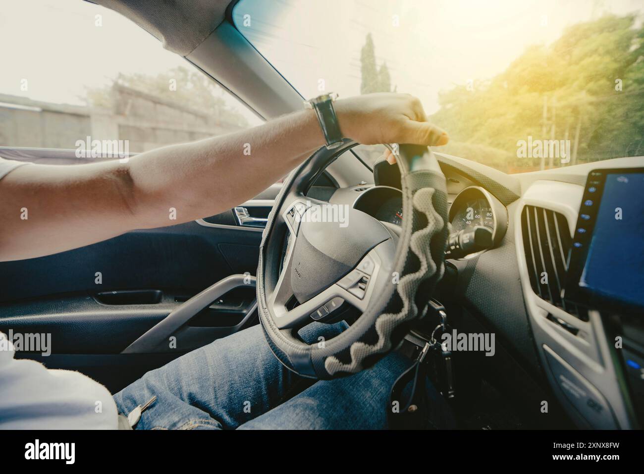 Person hands on the steering wheel driving the car. Close up of hands ...