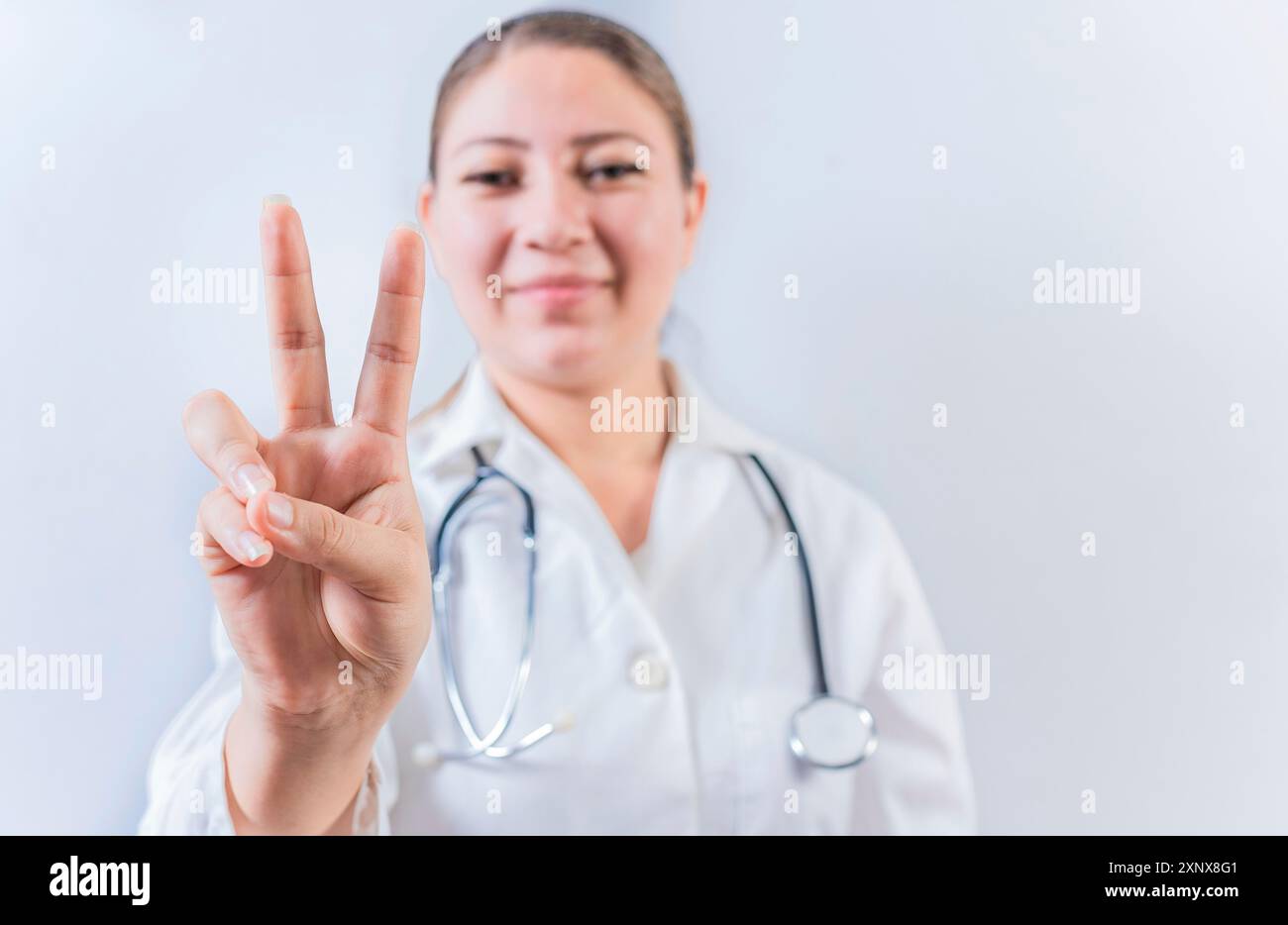 Female doctor counting number TWO isolated. Young female doctor ... Female doctor counting number TWO isolated. Young female doctor ...