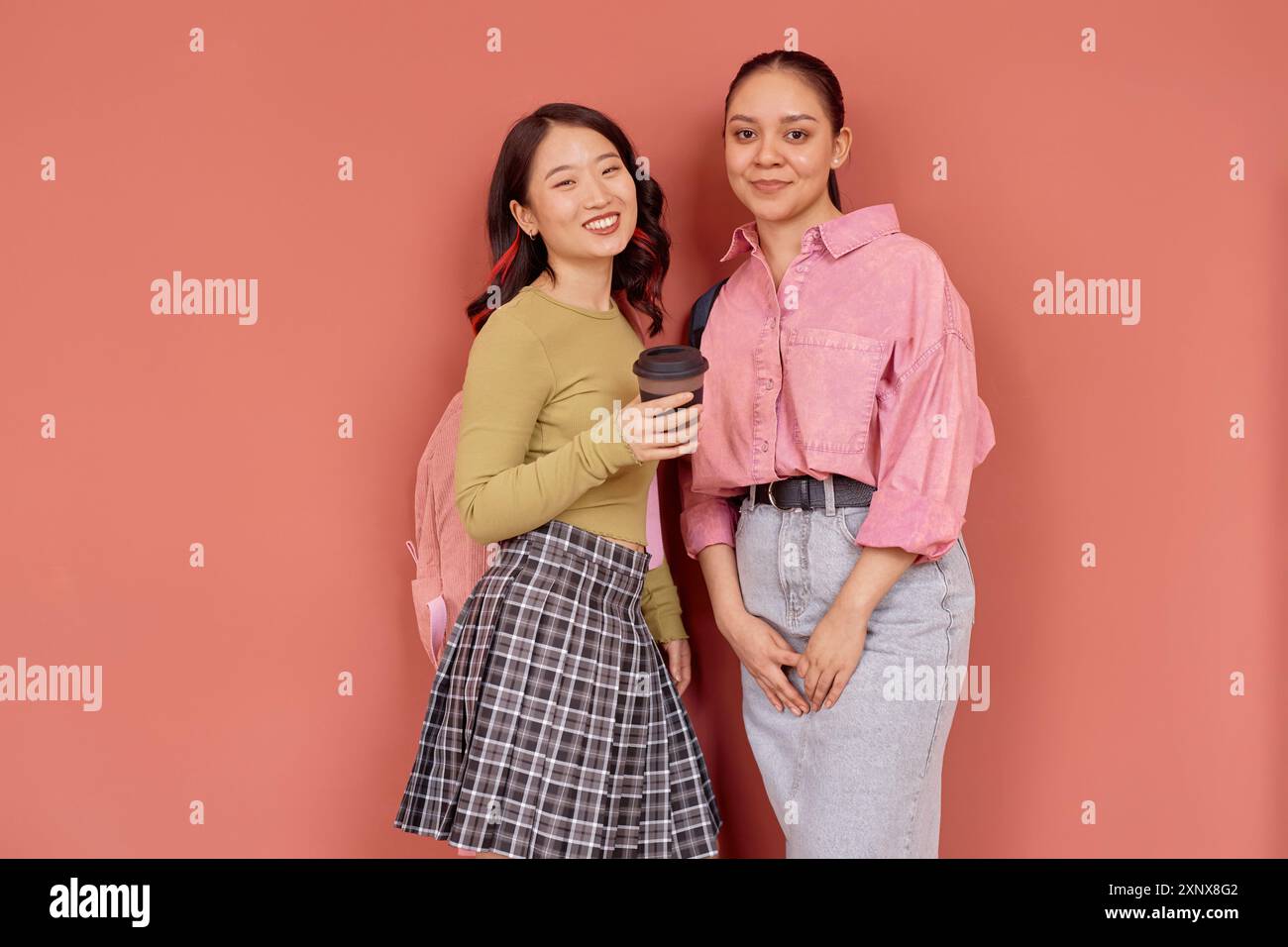 Portrait shot of two smiling multiethnic female students wearing ...