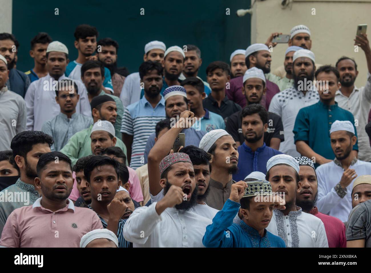 Dhaka, Bangladesh. 02nd Aug, 2024. Students from Qawmi Madrasa chant slogans and make gestures ...