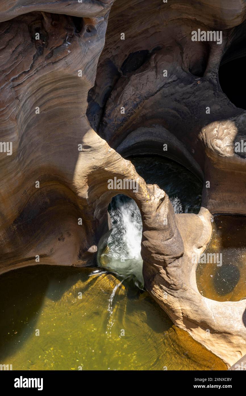 Water flowing through eroded rock formations, canyon with steep orange ...