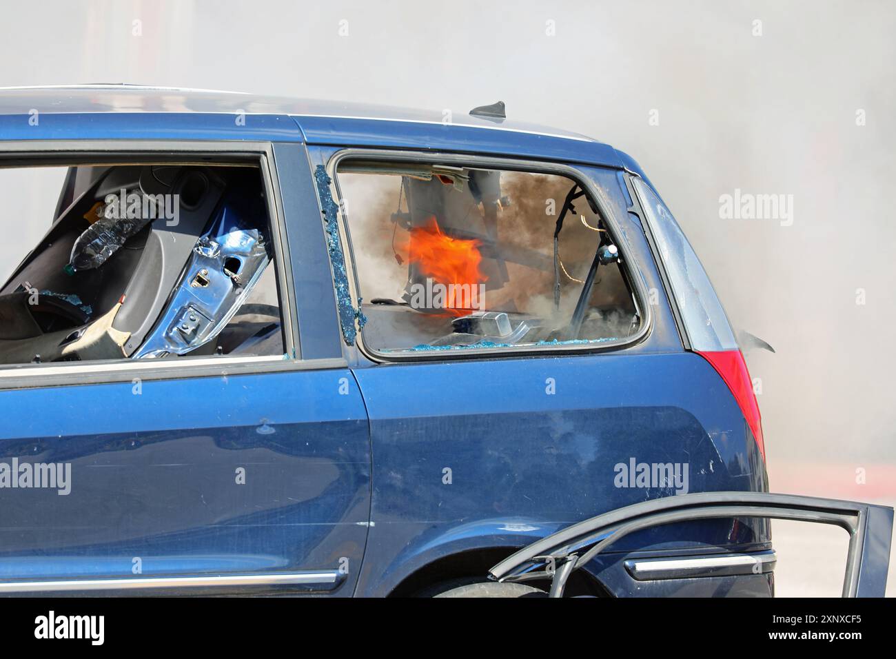 Initial stages of a fire with flames in the trunk of a wrecked car ...