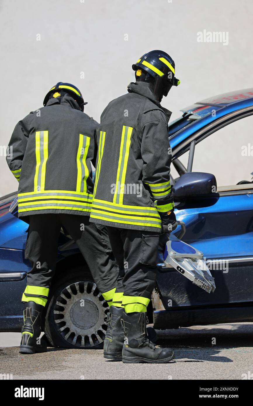 team of firefighters using powerful hydraulic shears and spreaders open ...