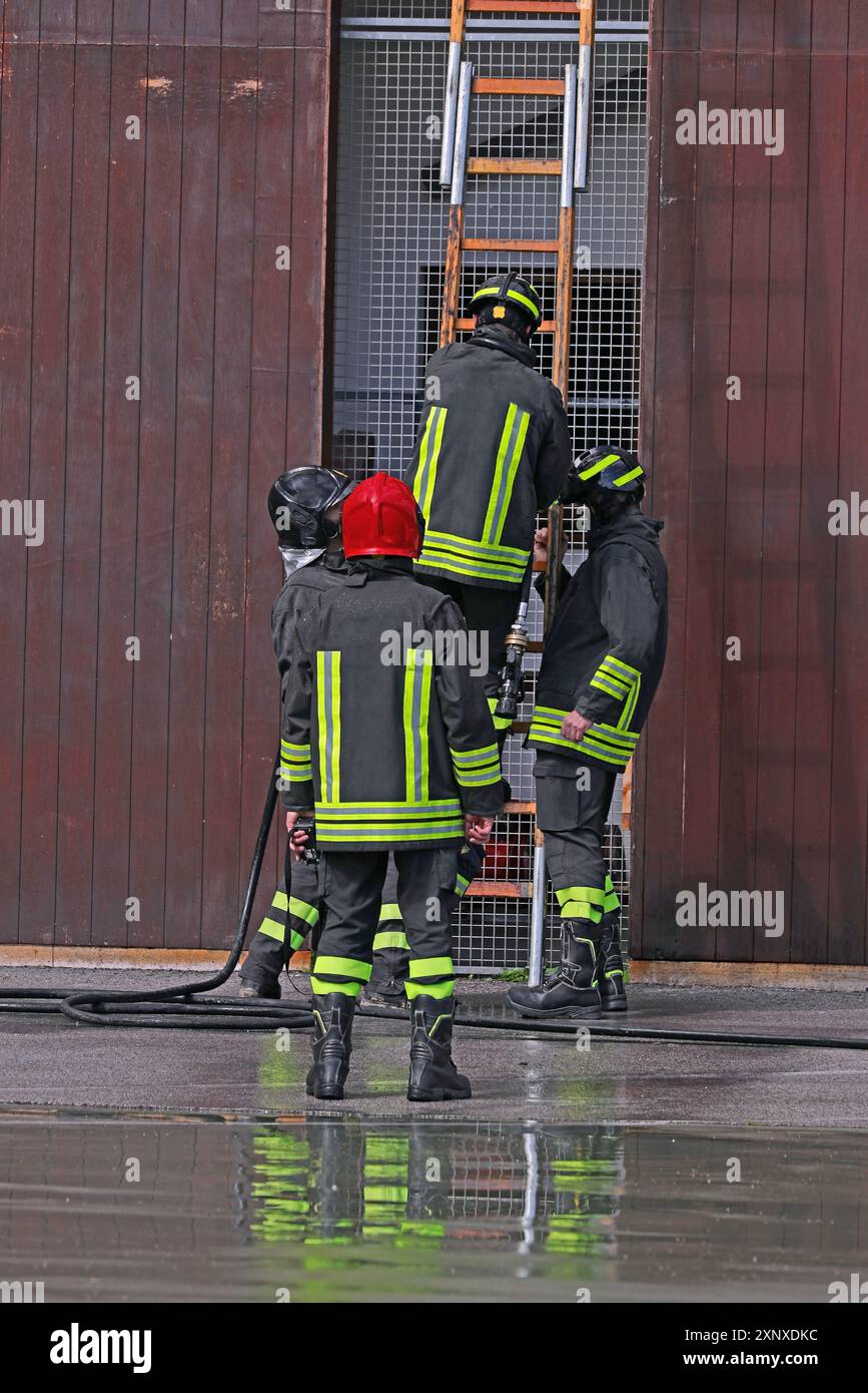Fireman chief coordinates firefighters assembling ladder to climb ...