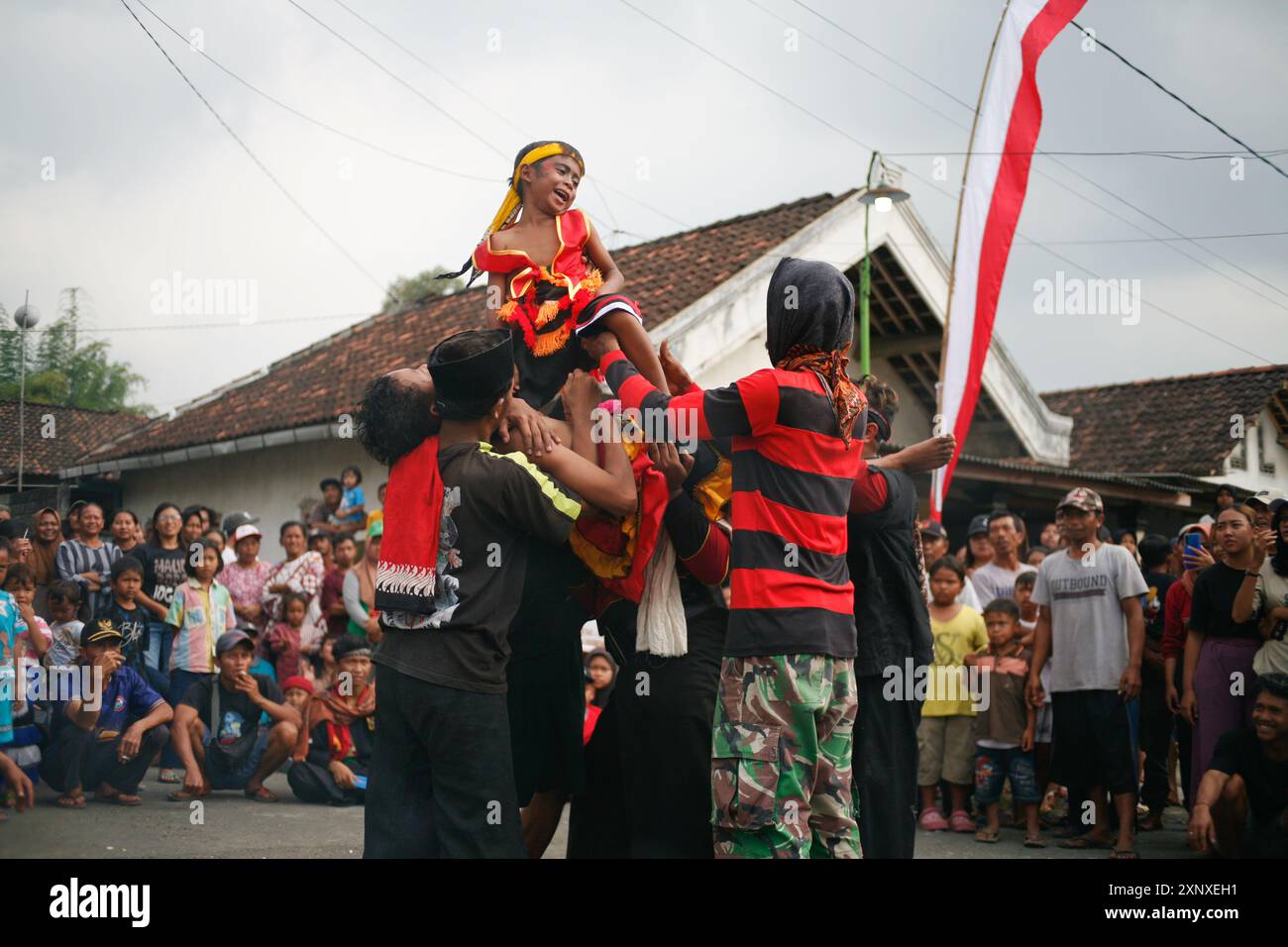 a boy standing on the body of a barong dancer fall into a trance in ...