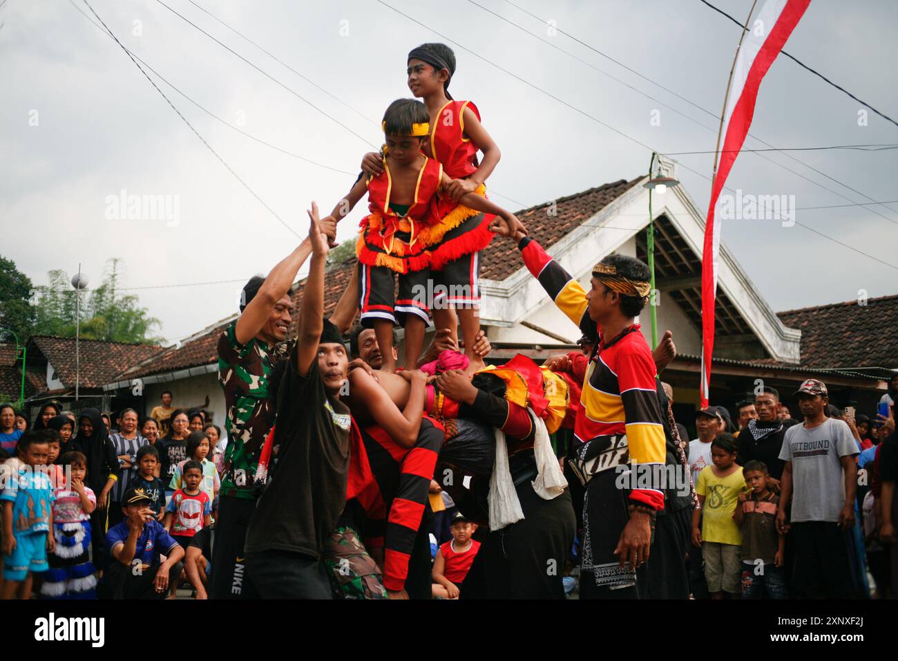 Two boys standing on the body of a barong dancer fall into a trance in ...
