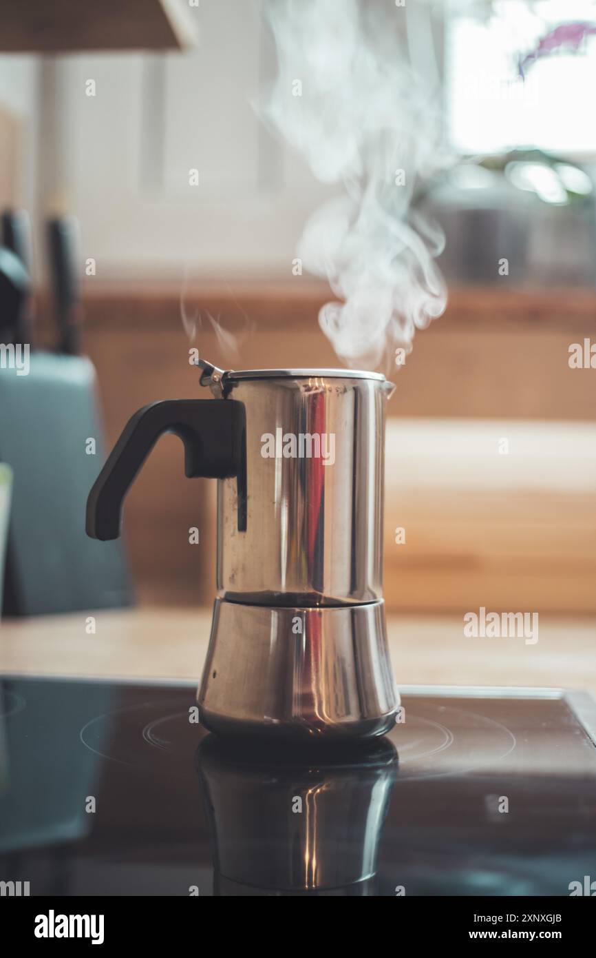 Italian coffee cooker on hot stove, breakfast Stock Photo - Alamy