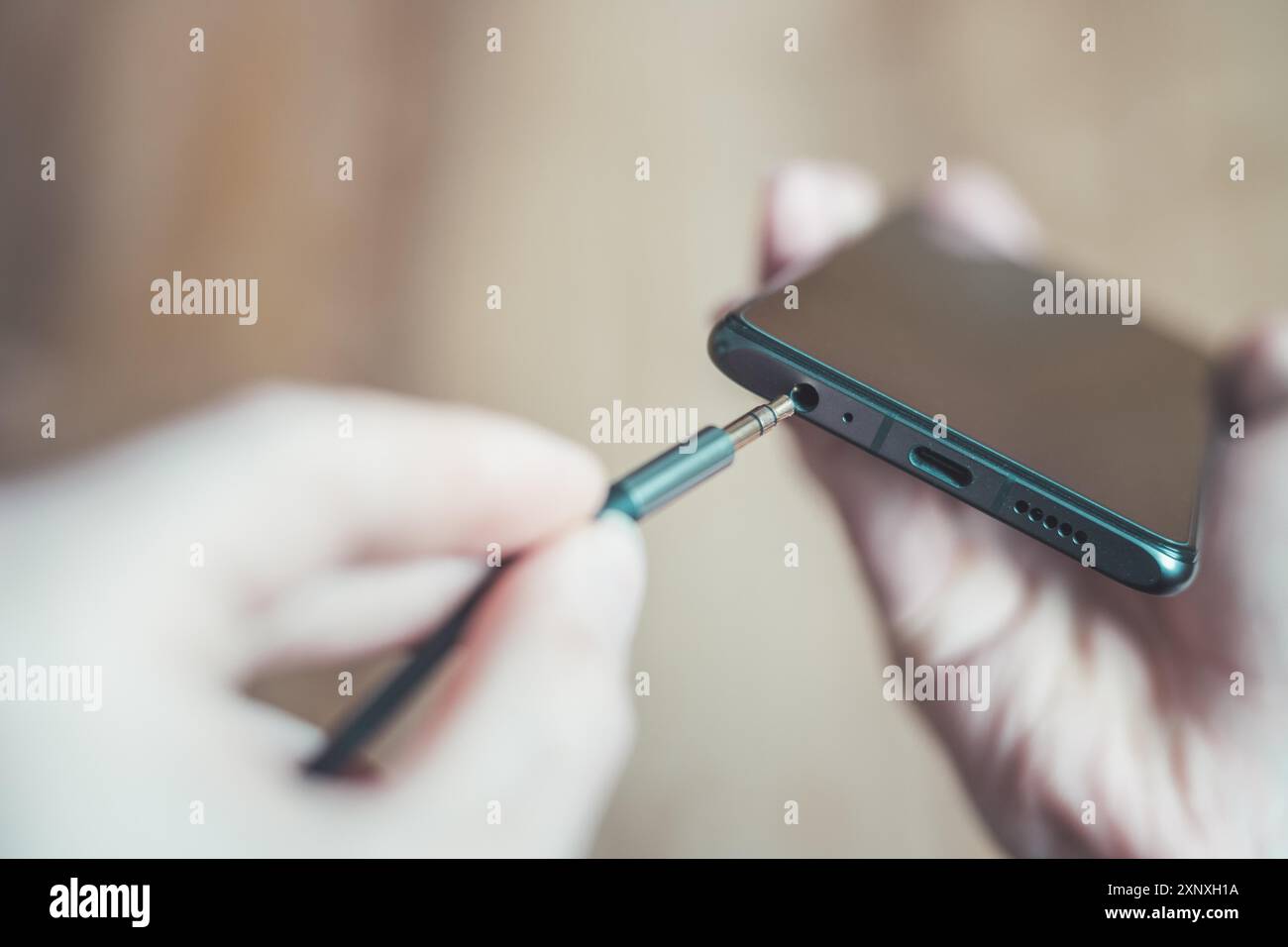 Connection 3.5mm audio jack to a black mobile phone Stock Photo - Alamy