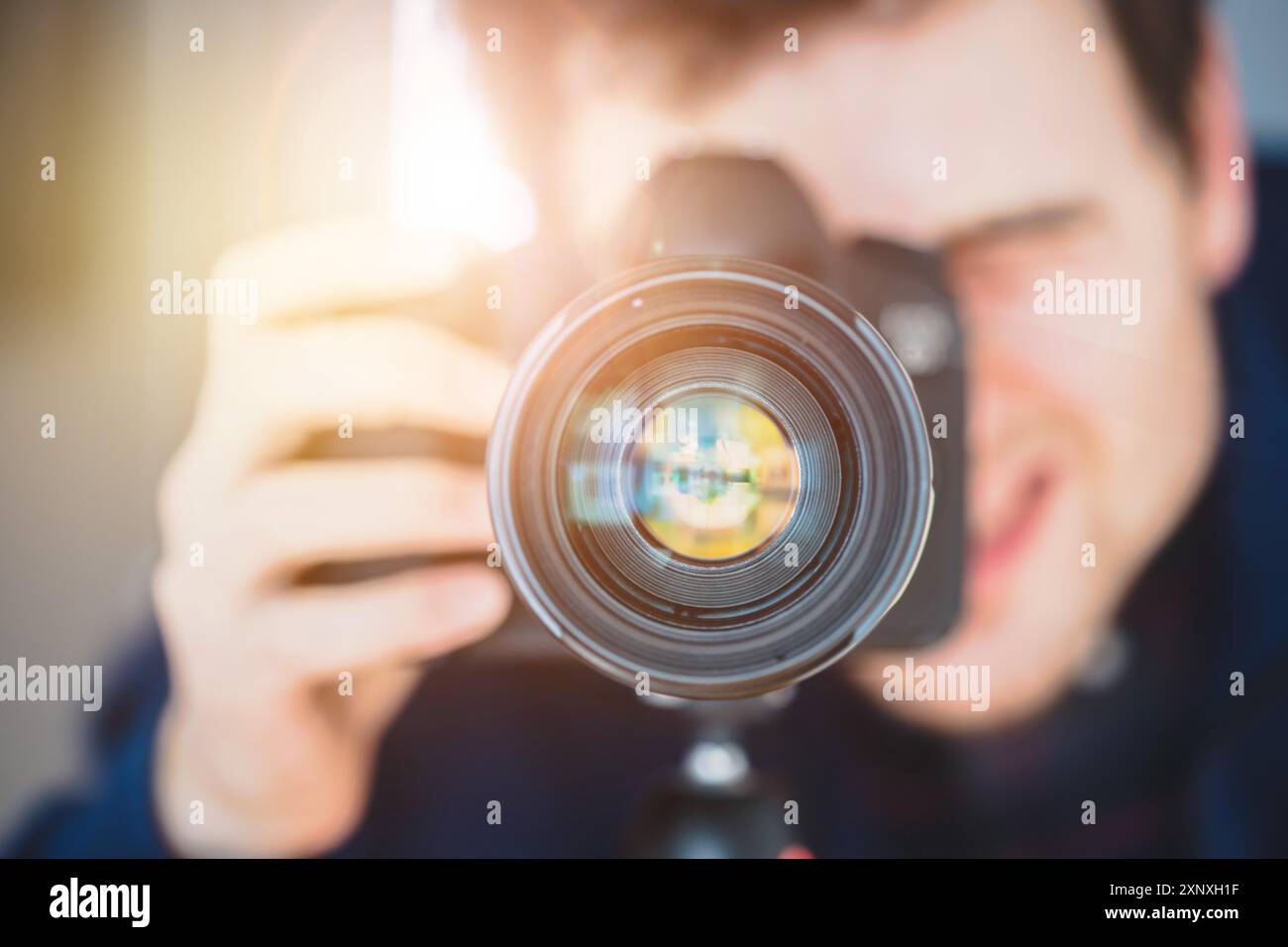Photographer is standing behind a professional camera with telephoto ...