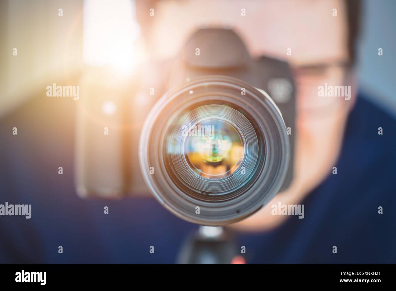Photographer is standing behind a professional camera with telephoto ...