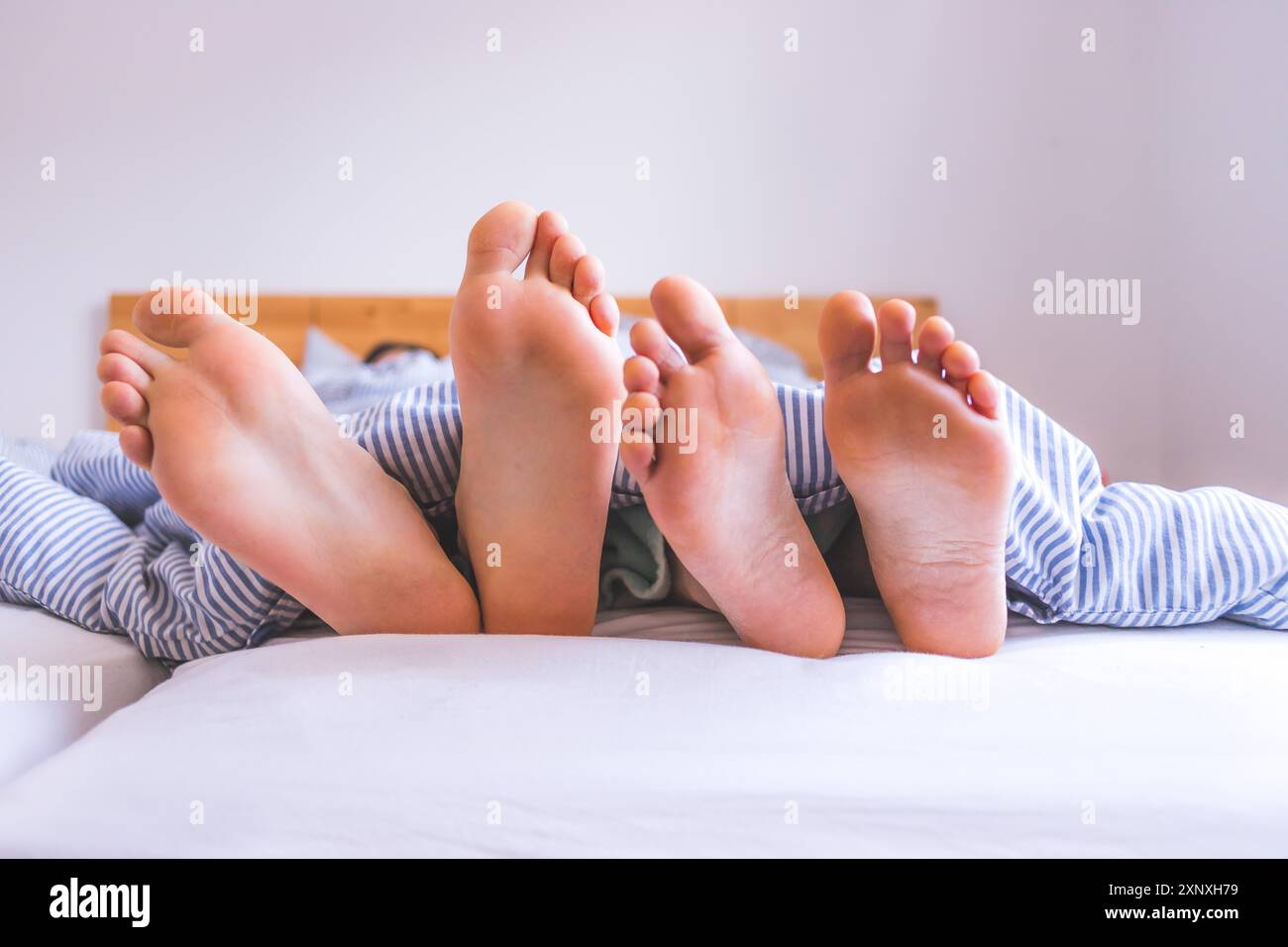 Close up a couples uncovered feet sleeping in bed, morning Stock Photo ...