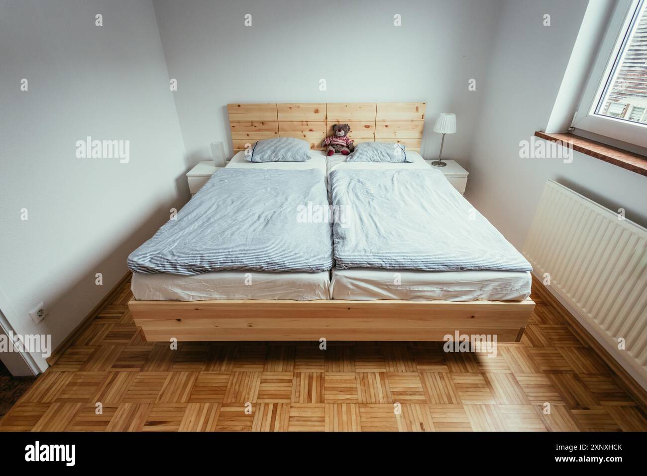 Large comfortable stone pine bed in bedroom Stock Photo - Alamy