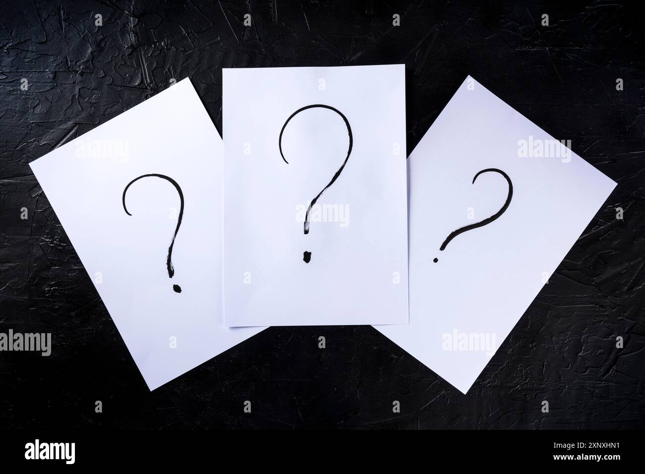 Question marks, written in ink on a piece of standard office paper ...