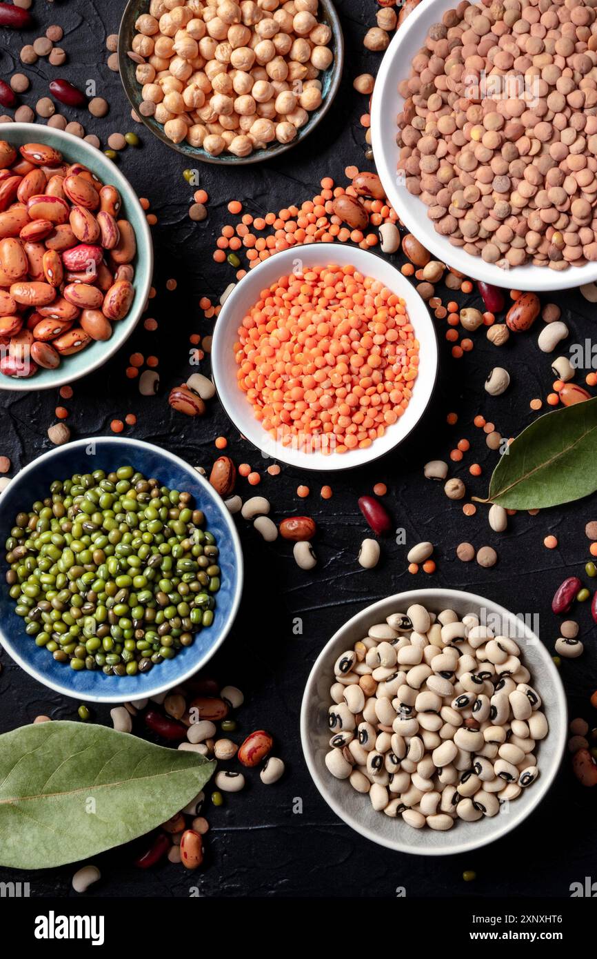 Legumes variety, overhead shot on a black background. Lentils, soybeans ...