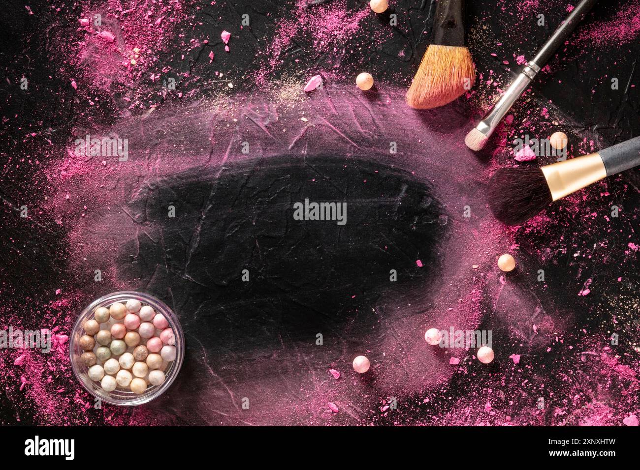 Make-up brushes with crushed cosmetics on a black background, with copy ...
