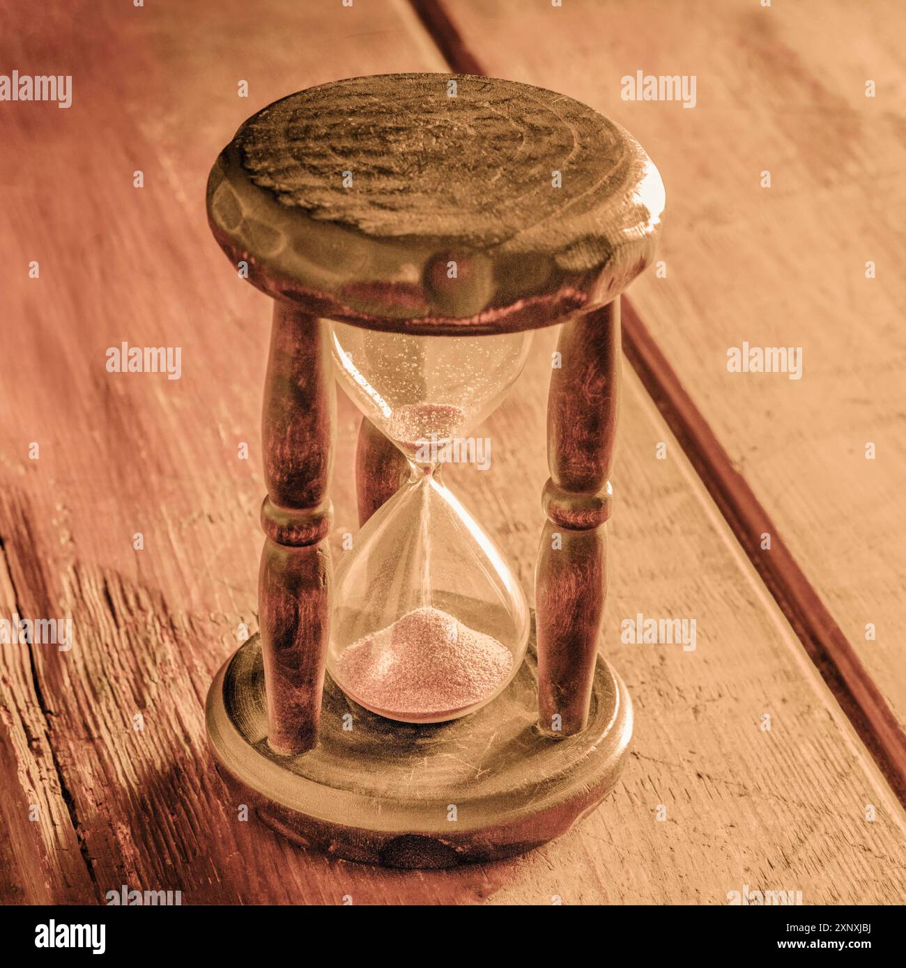 Time concept. A vintage hourglass with sand falling through, on a ...