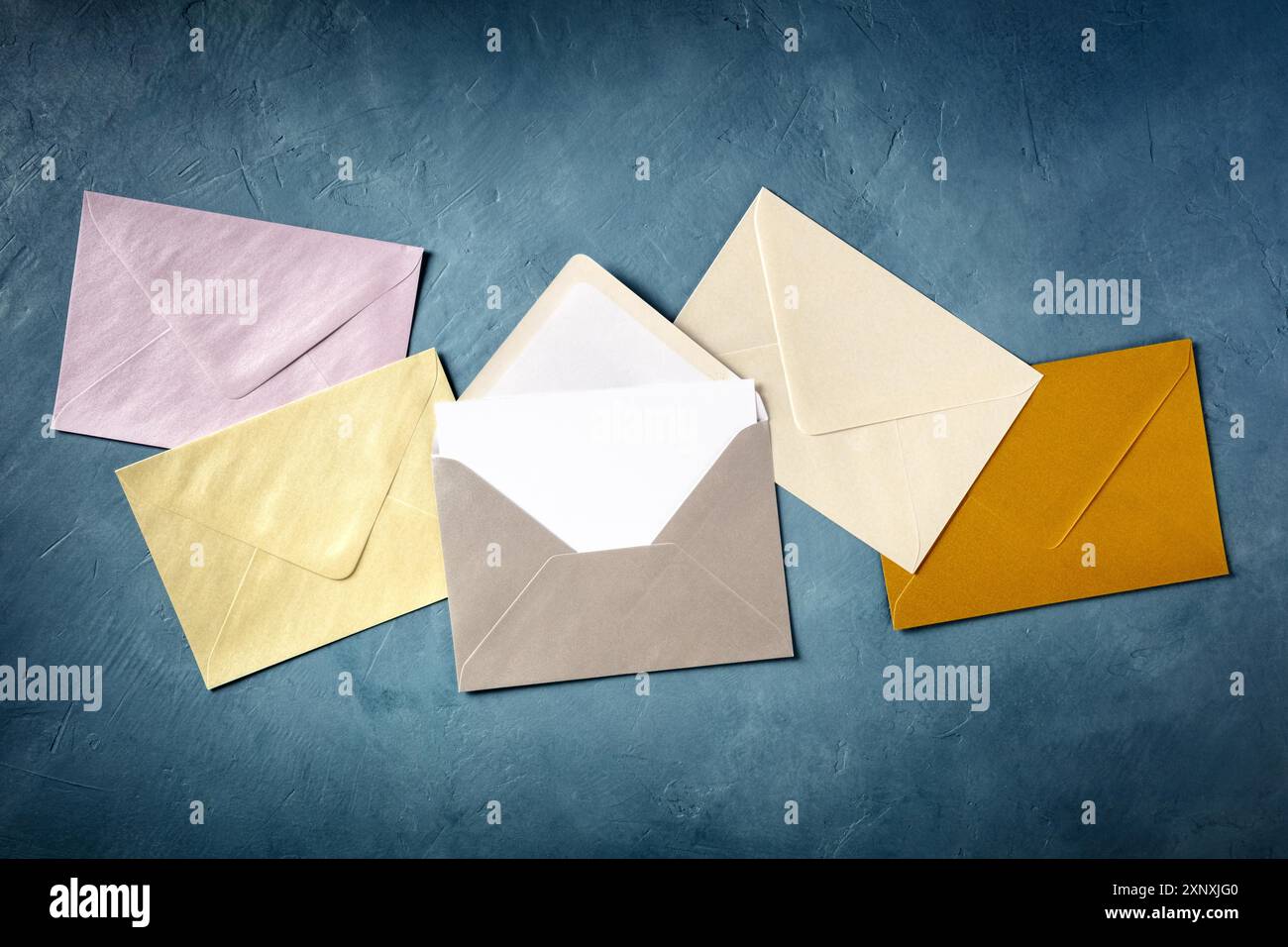 Glossy envelopes and a postcard, shot from above on a dark blue ...