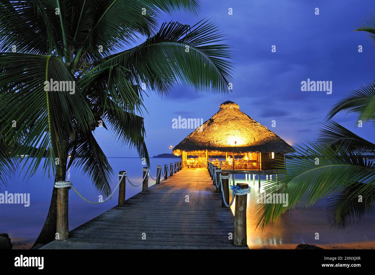 Bar and restaurant on stilts at dusk, Playa Tortuga hotel, Colon Island ...