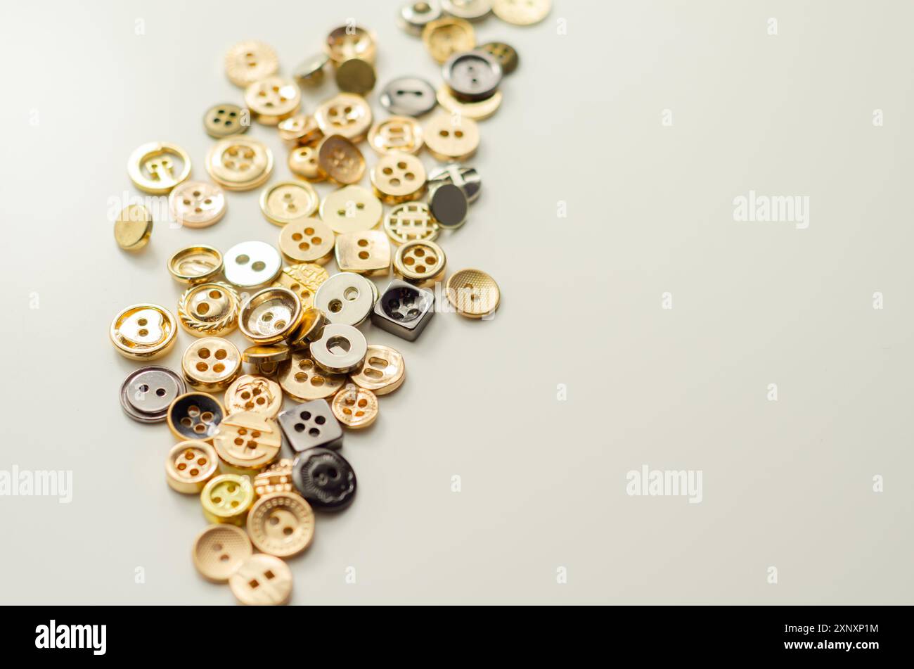 A pile of buttons of various shapes and sizes. The buttons are ...