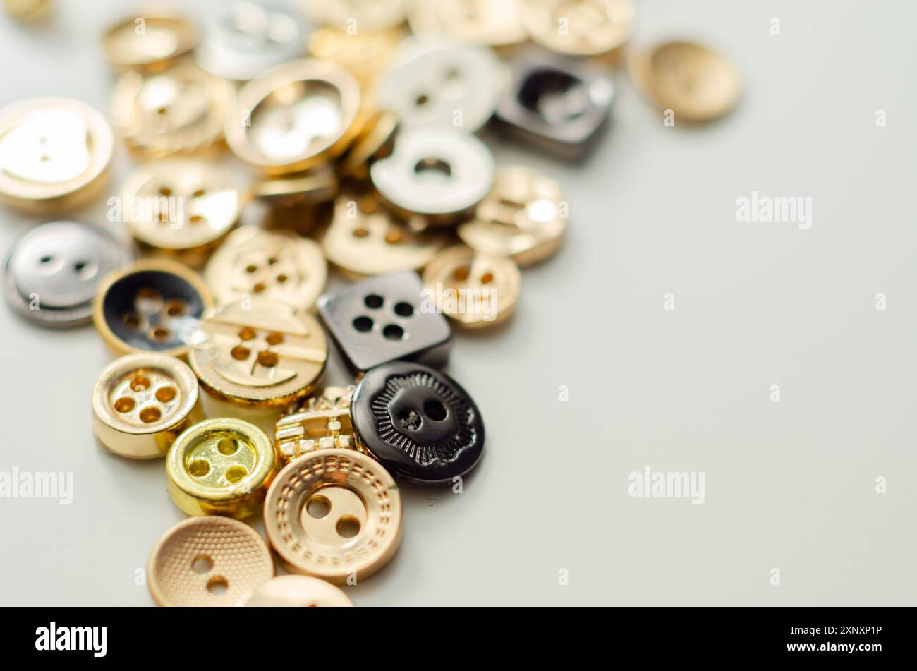 A pile of buttons of various shapes and sizes. The buttons are ...
