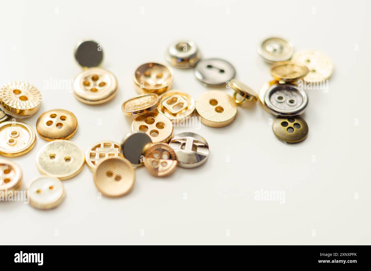 A pile of buttons of various shapes and sizes. The buttons are ...