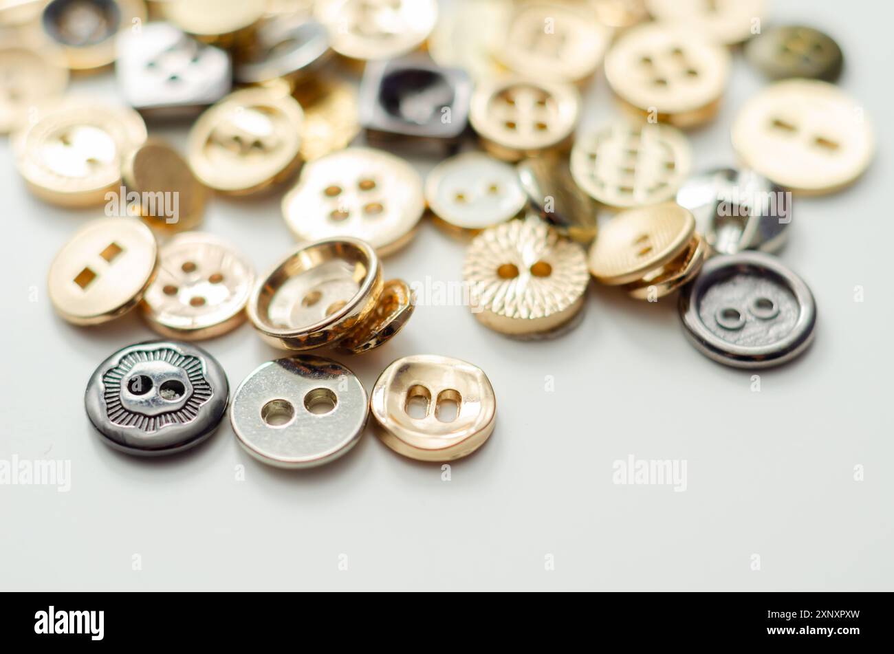 A pile of buttons of various shapes and sizes. The buttons are ...