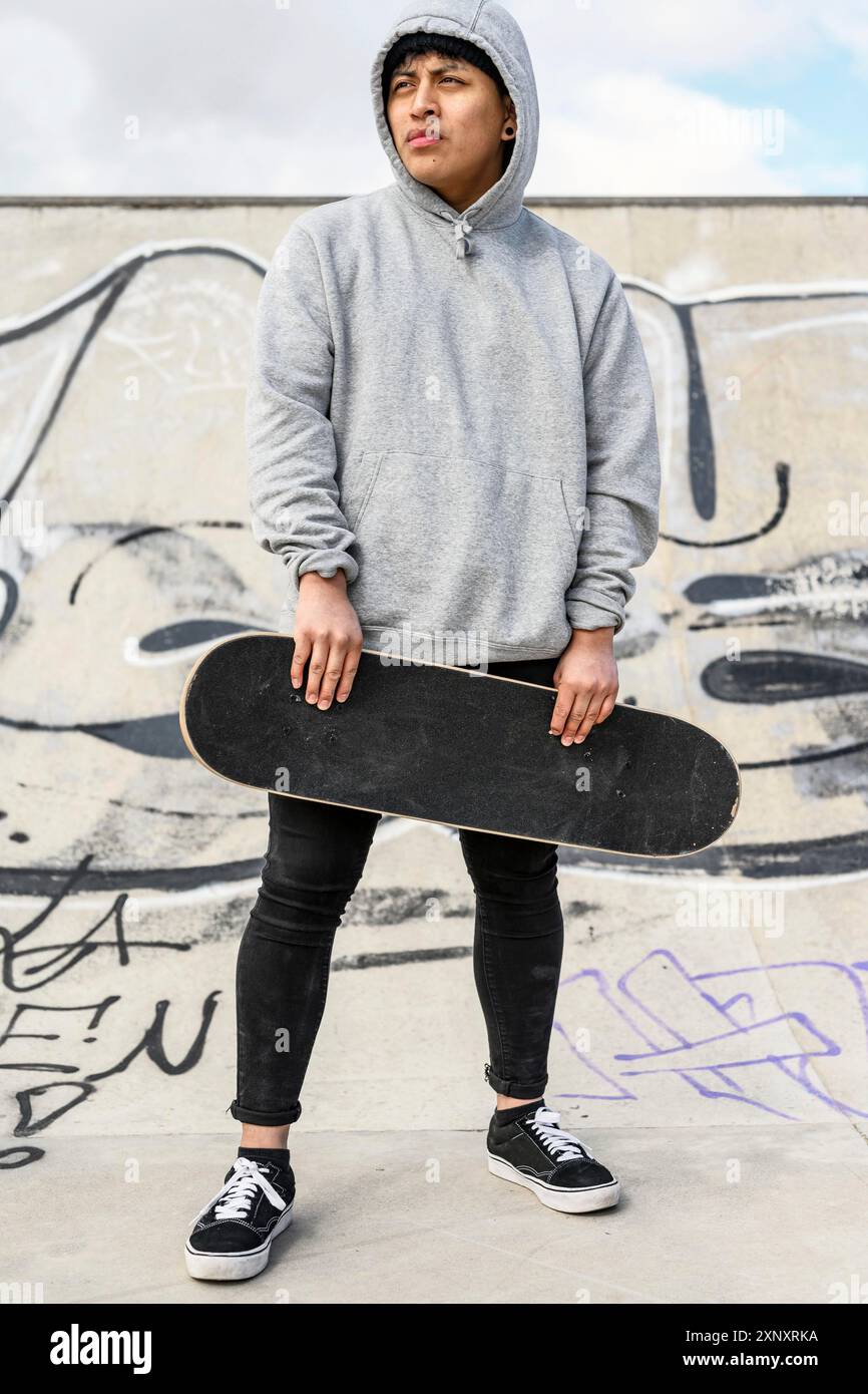 Young skater posing with skateboard at skate park Stock Photo - Alamy
